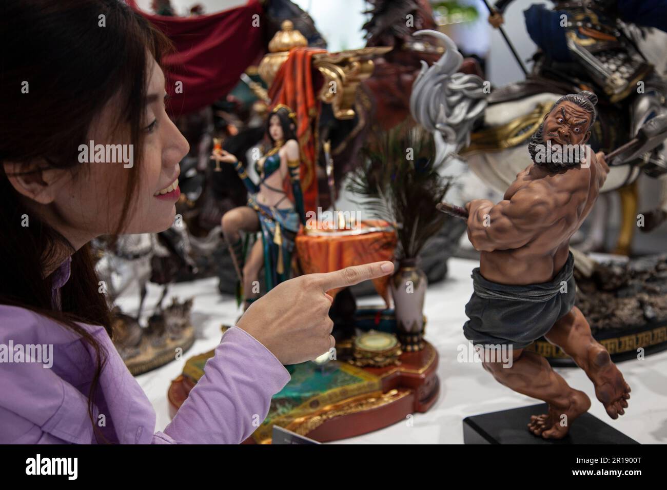 Visitors observe a collection of superhero statues at Statue4Heroes ...