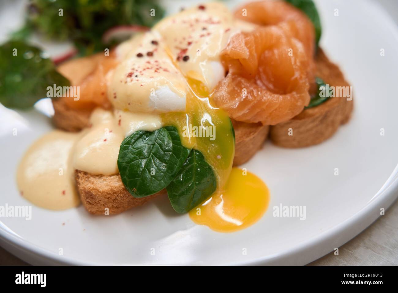 Yolk from egg flowing out onto toast with red fish Stock Photo - Alamy