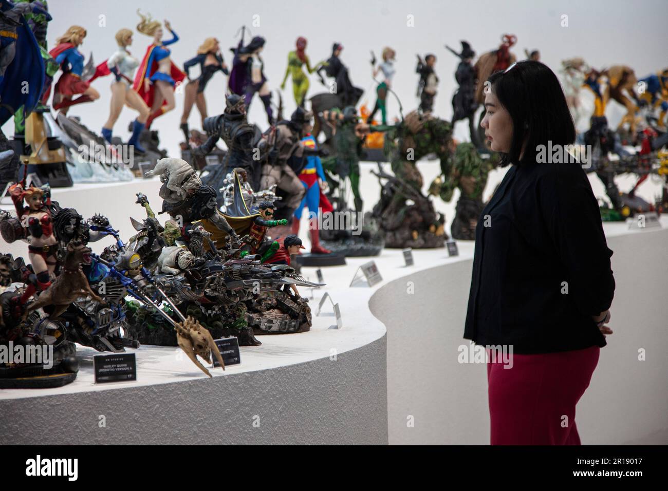 Visitors observe a collection of superhero statues at Statue4Heroes ...
