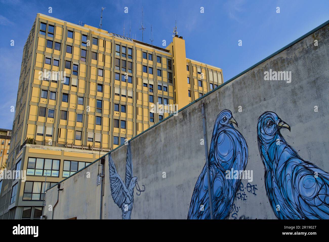 Yellow building and blue graffiti Stock Photo - Alamy