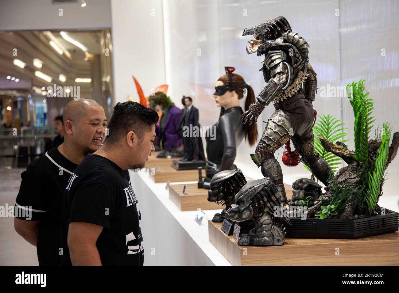 Visitors observe a collection of superhero statues at Statue4Heroes ...