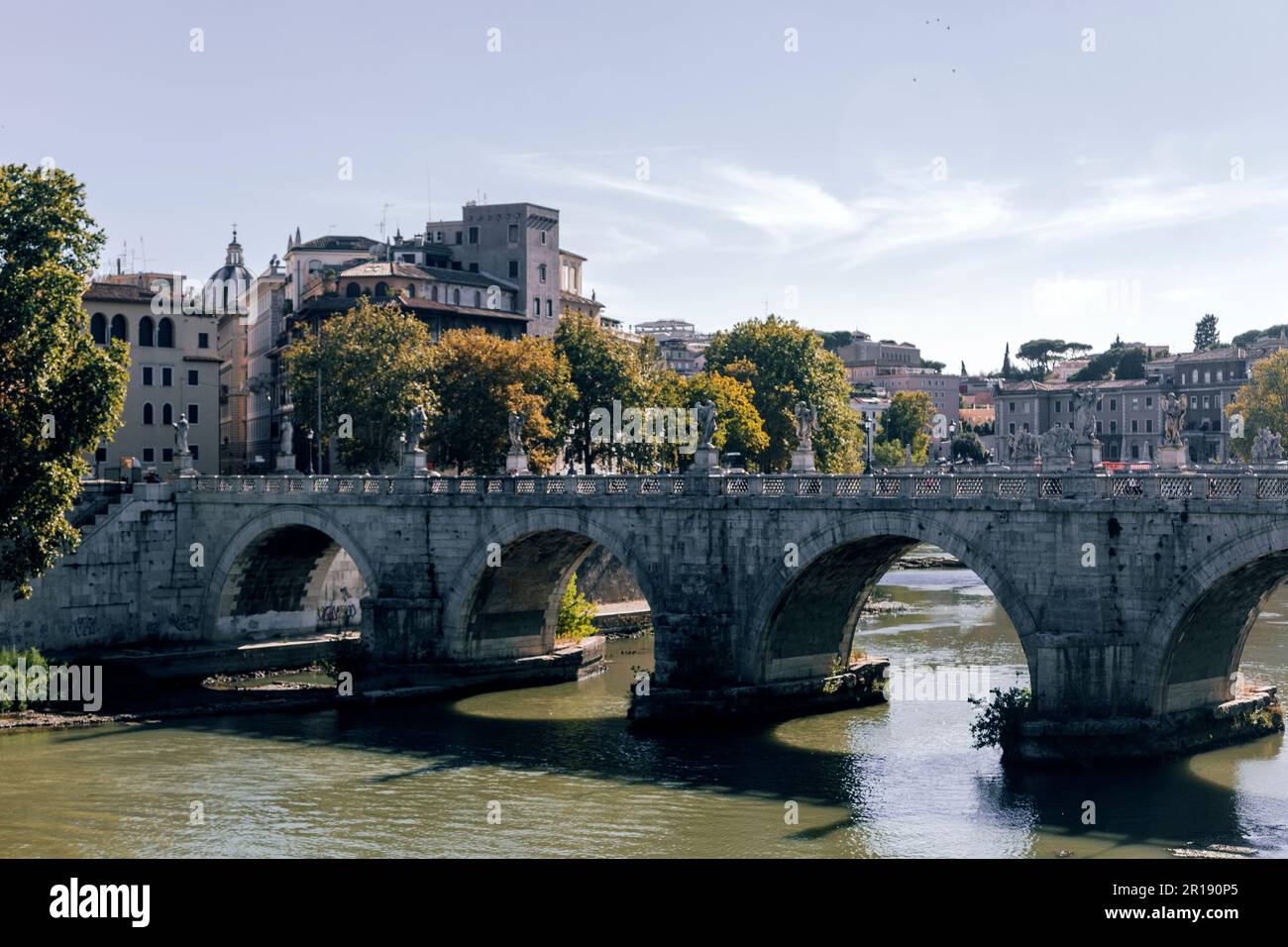 A bridge with sculptures over the Tiber river in Rome, Italy Stock ...