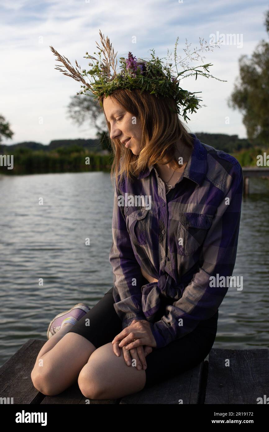lifestyle portrait of a beautiful woman in a wreath of wildflowers ...