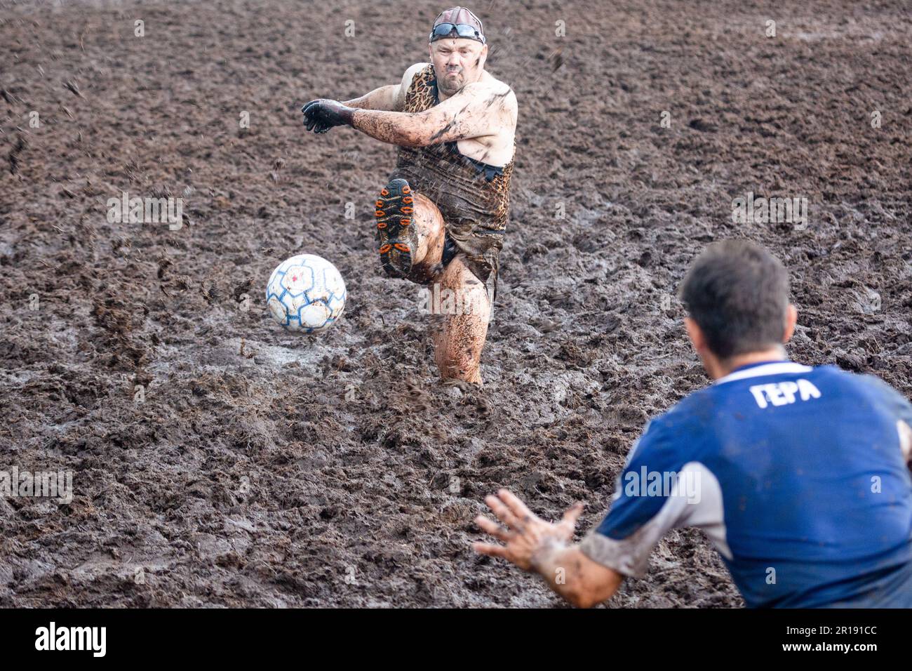 SWAMP SOCCER, FINLAND, 2014: A goalkeeper in action trying to prevent a ...