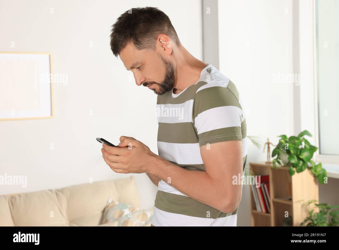 Man with poor posture using smartphone at home Stock Photo - Alamy