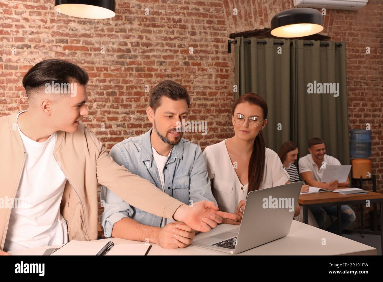 Team of employees working together in office Stock Photo - Alamy