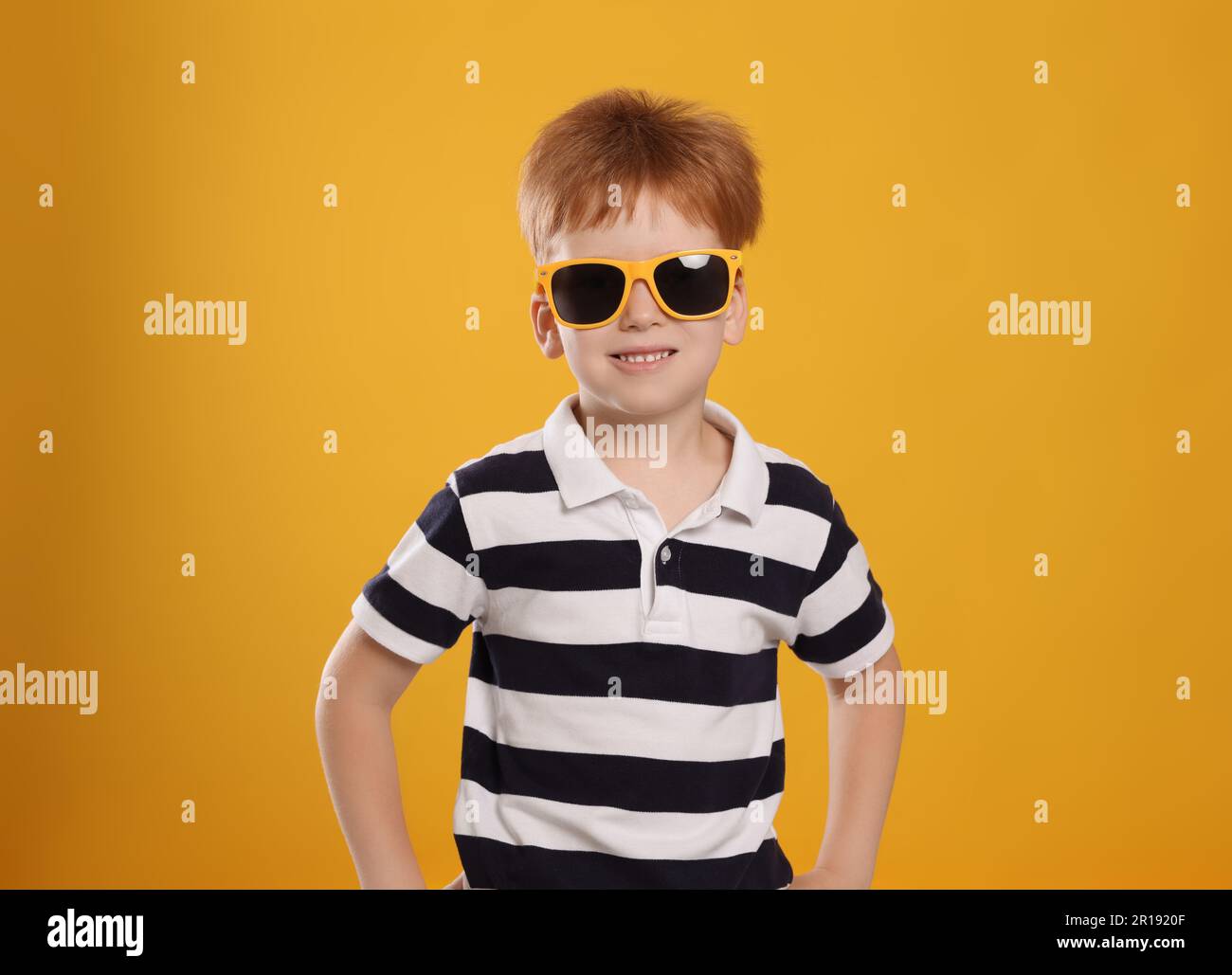 Cute little boy with sunglasses on yellow background Stock Photo - Alamy