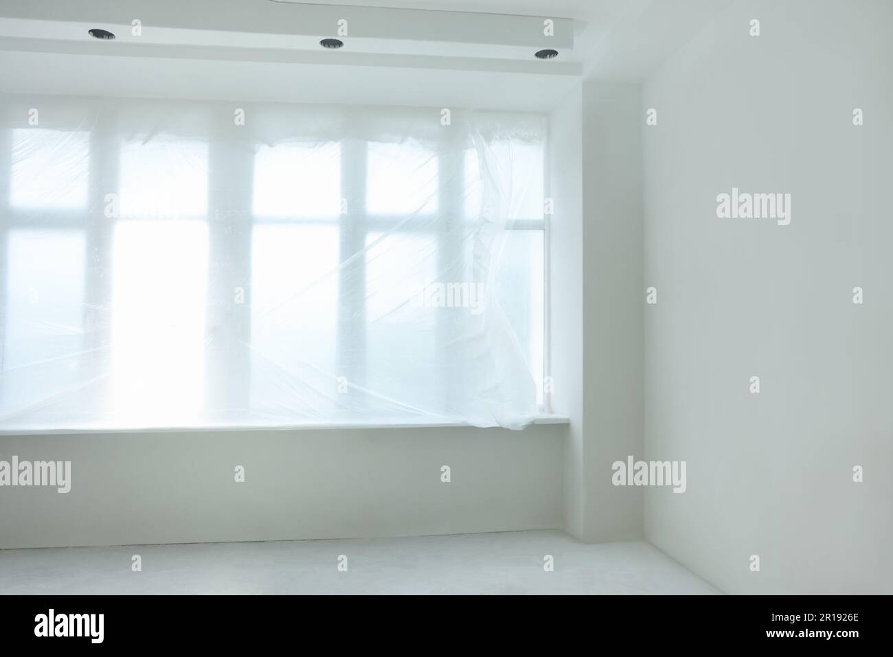 Big windows covered with plastic film indoors Stock Photo - Alamy