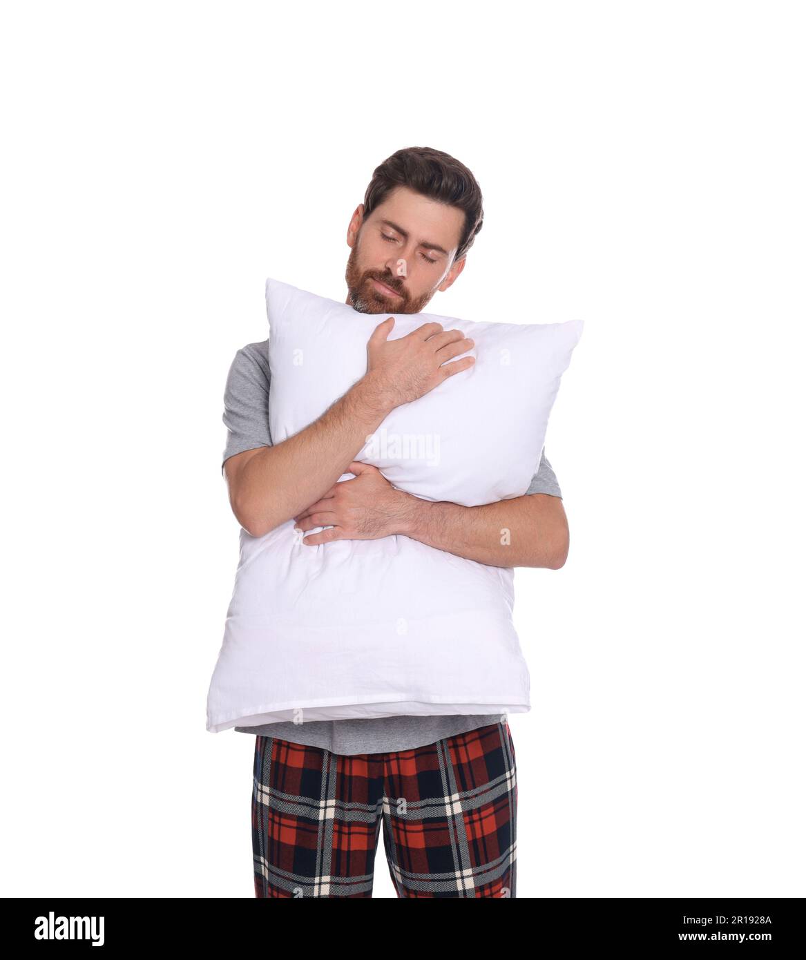 Sleepy handsome man hugging soft pillow on white background Stock Photo ...