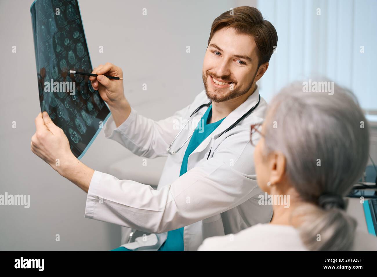 Pleasant young doctor is holding mri scan in his hands Stock Photo - Alamy