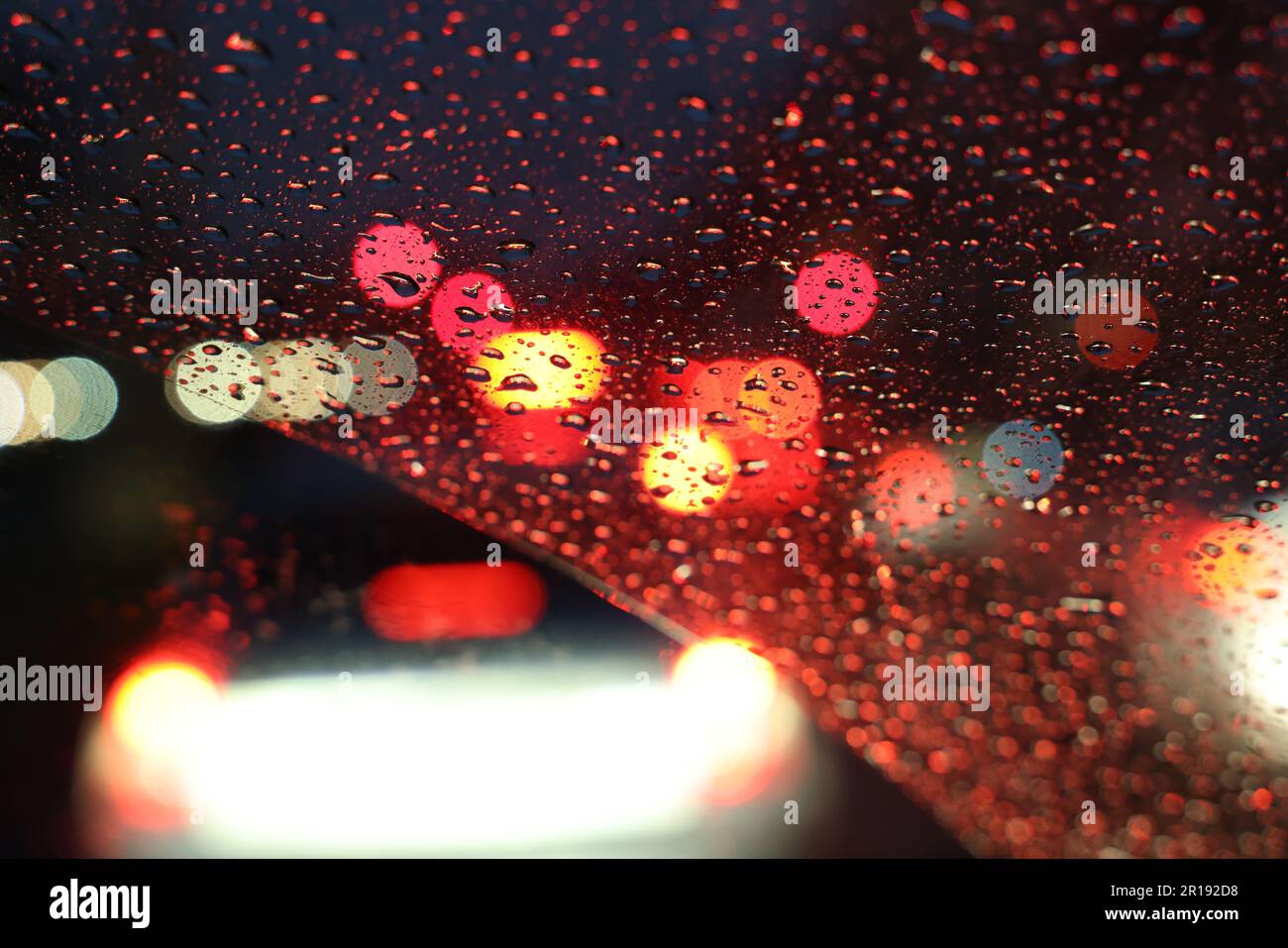 Blurred view of road through wet car window at night. Bokeh effect ...