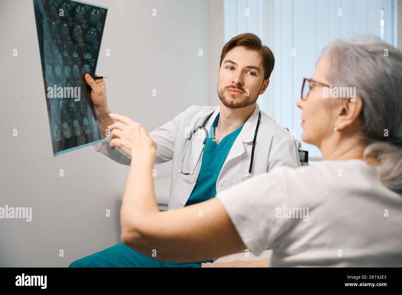 Therapist shows a patient an MRI scan of the brain Stock Photo - Alamy