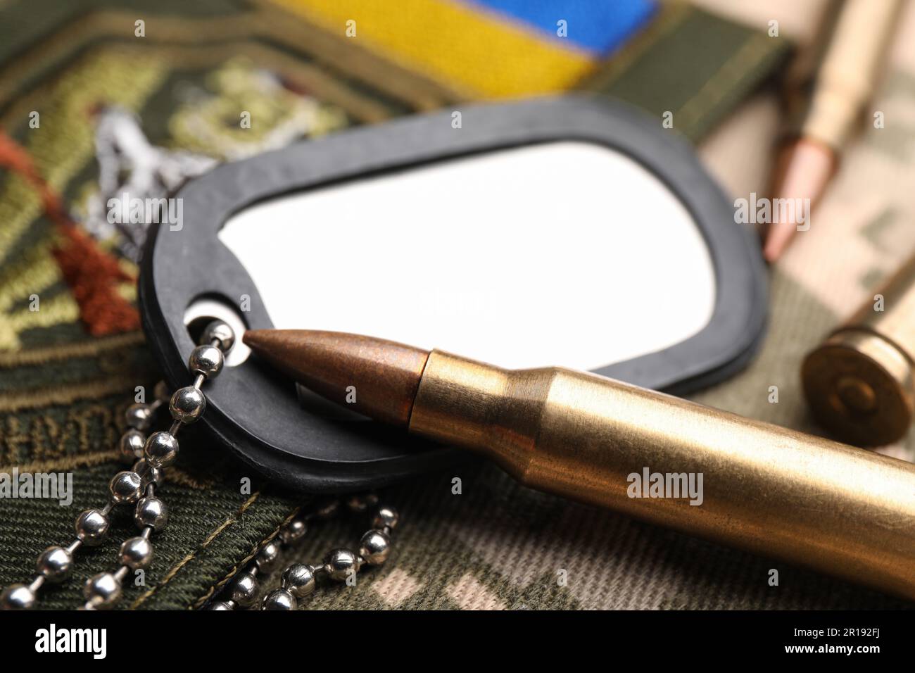 Bullets, military ID tag and Ukrainian patch on pixel camouflage ...