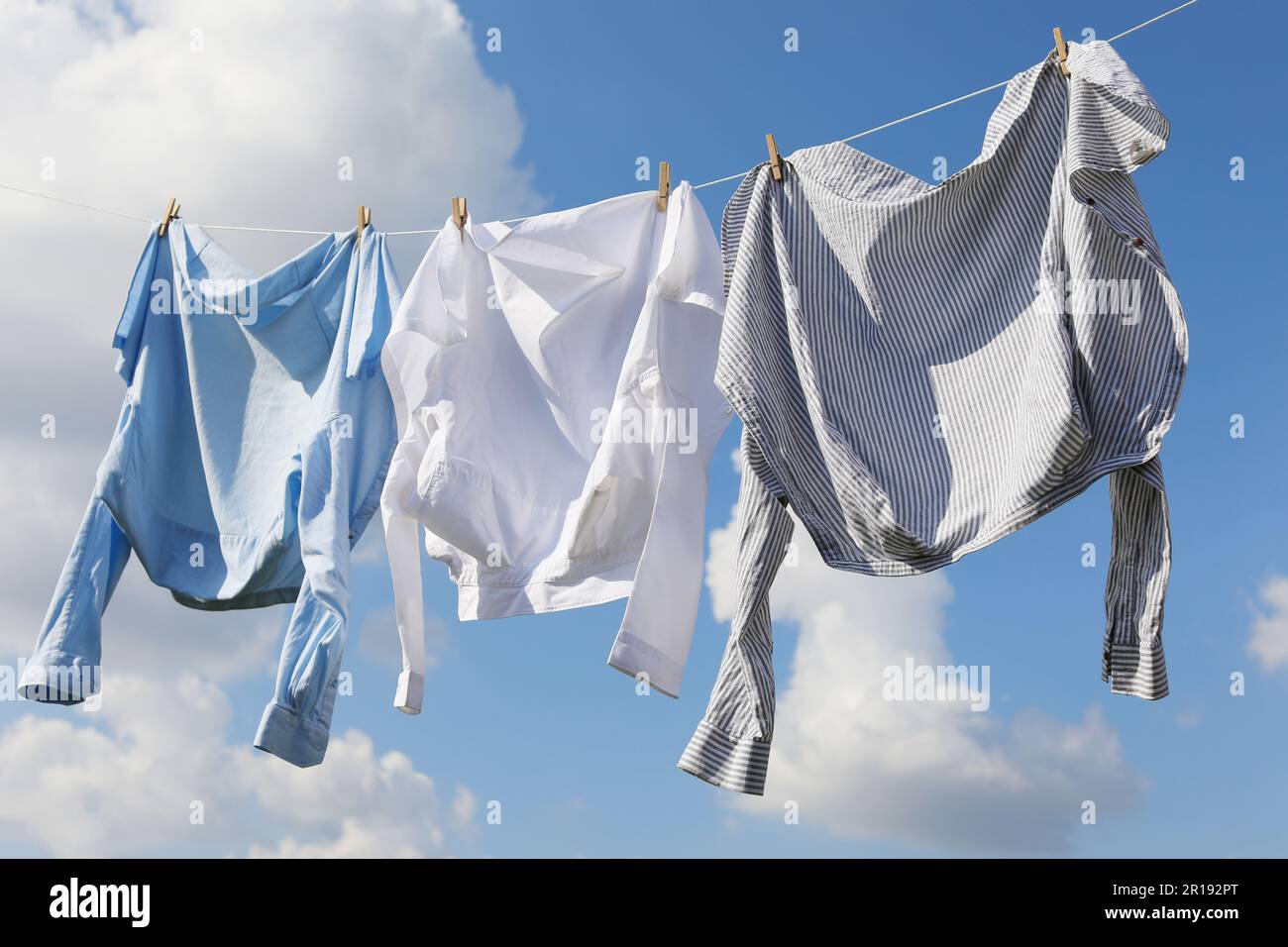 Clean clothes hanging on washing line against sky. Drying laundry Stock ...