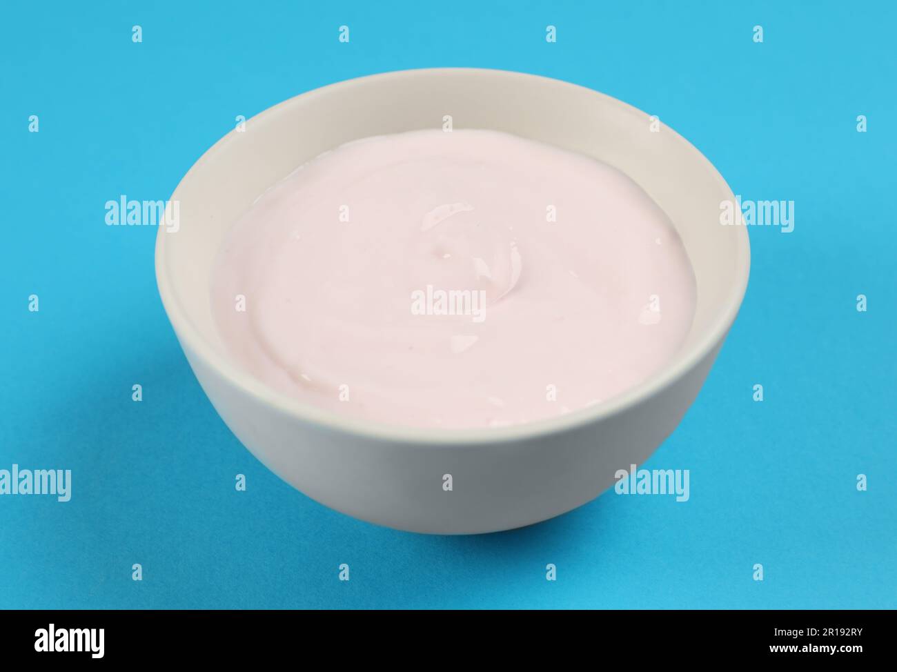 Bowl of tasty organic yogurt on light blue background Stock Photo - Alamy