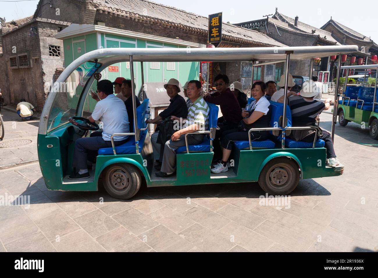 Chinese electric tour bus cart travel the city's narrow streets with ...
