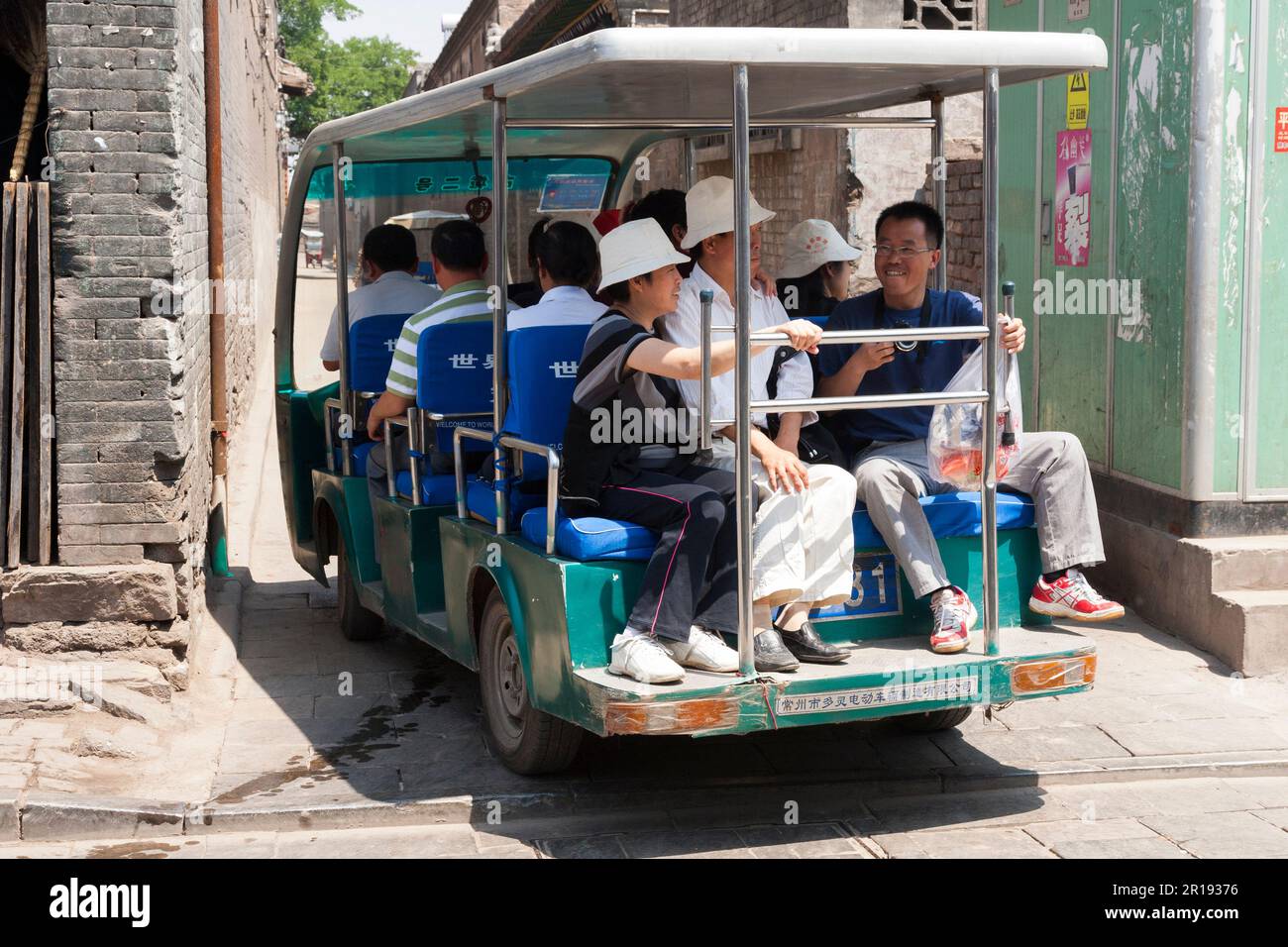 Chinese electric tour bus cart travel the city's narrow streets with ...