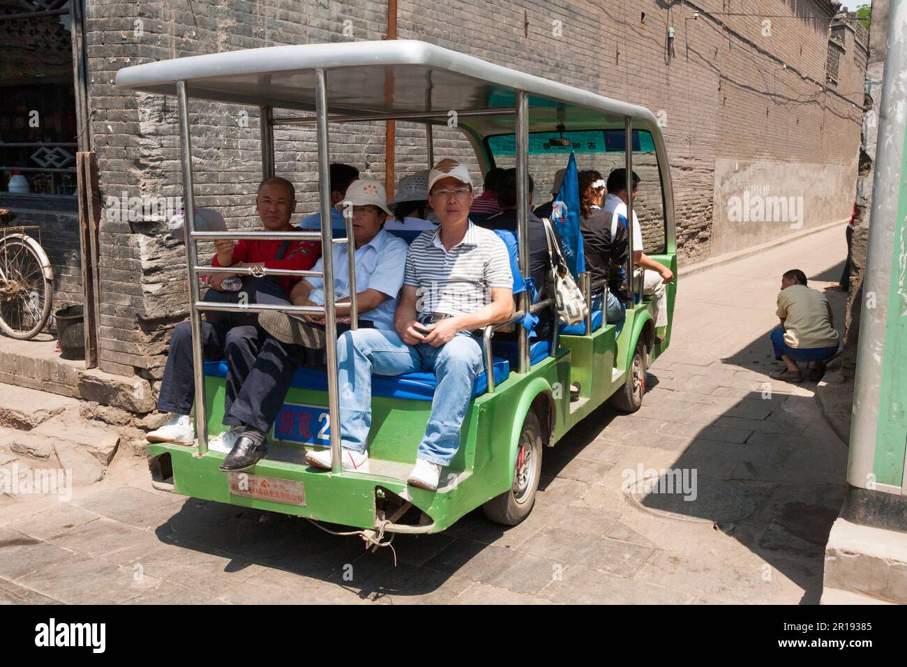 Chinese electric tour bus cart travel the city's narrow streets with ...
