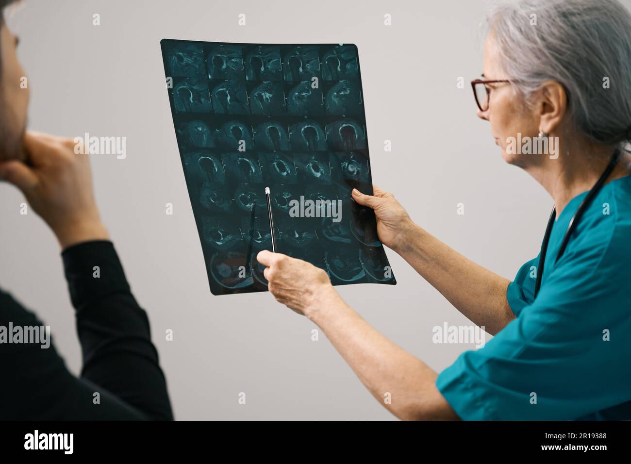 Elderly female therapist shows a patient an MRI scan of the brain Stock ...