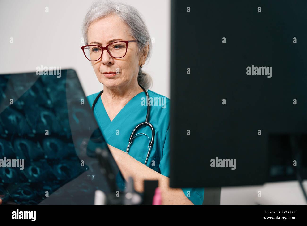 Beautiful elderly female doctor holds an MRI scan of brain Stock Photo ...