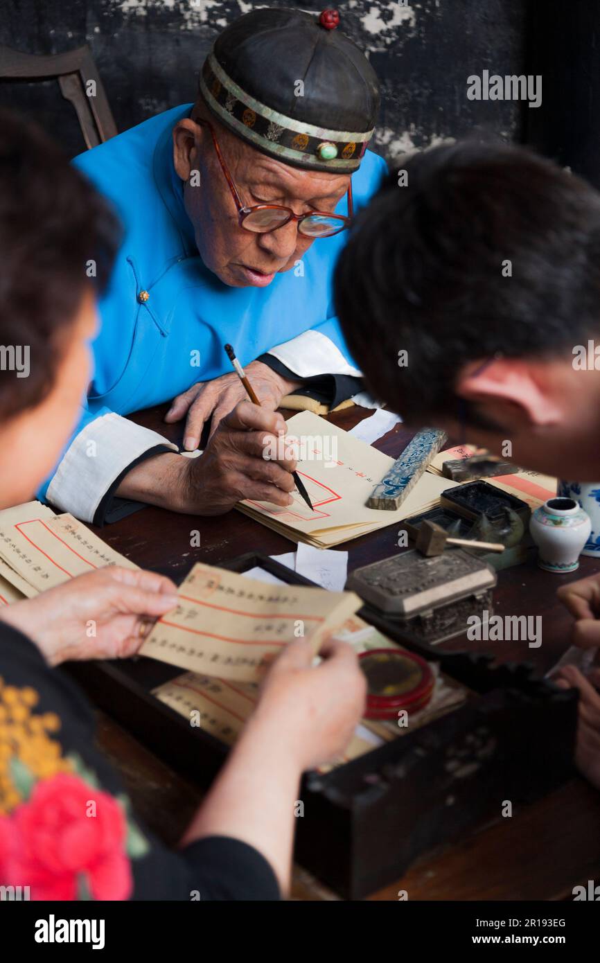 Mature Chinese man giving calligraphy demonstrations to tourists at The ...