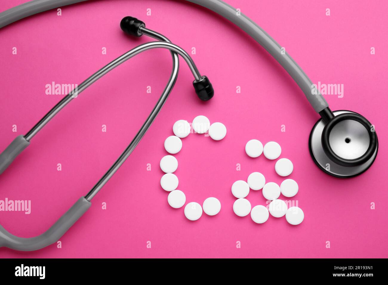 Stethoscope and calcium symbol made of white pills on bright pink ...