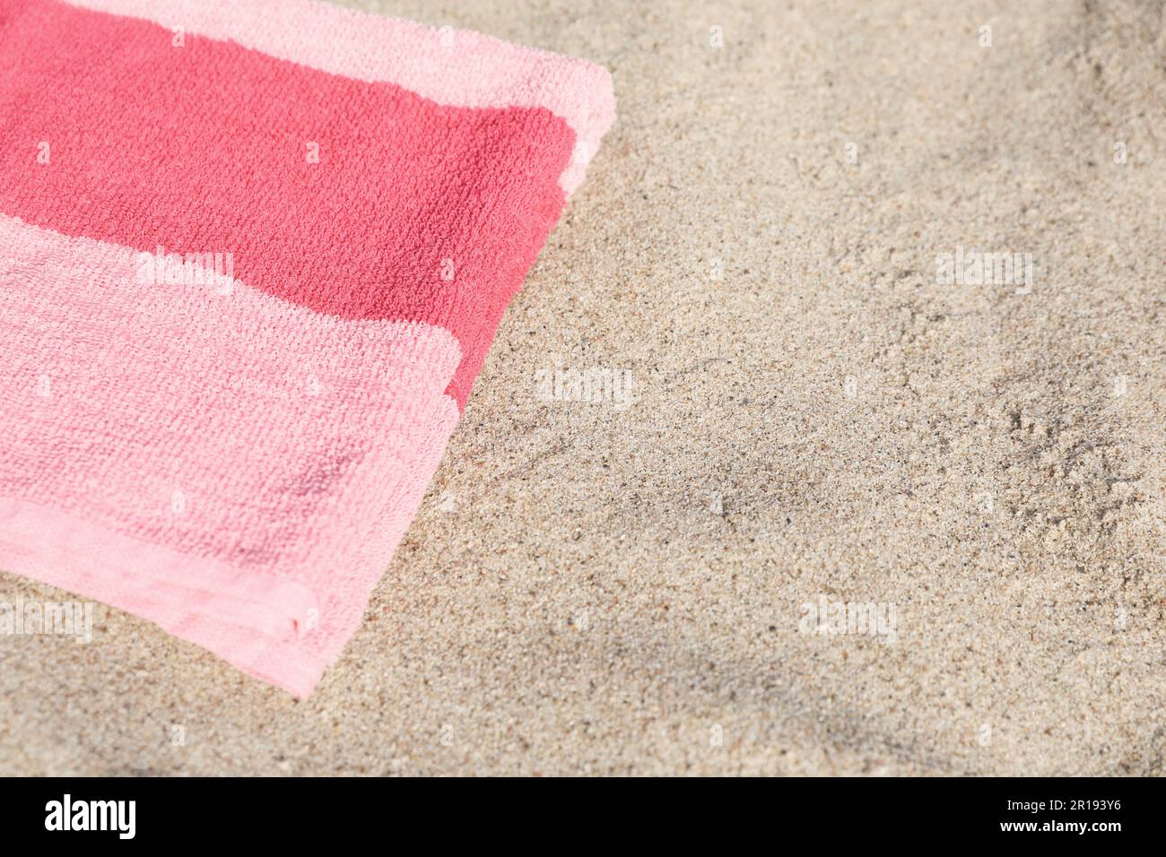Soft pink beach towel on sand, space for text Stock Photo - Alamy