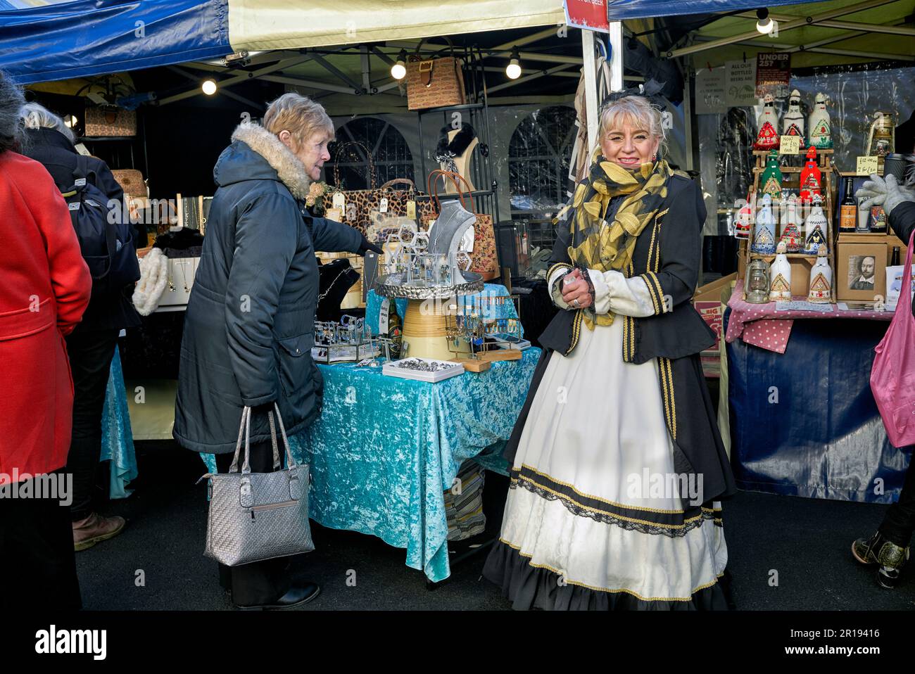Victorian street festival with woman market trader in traditional ...