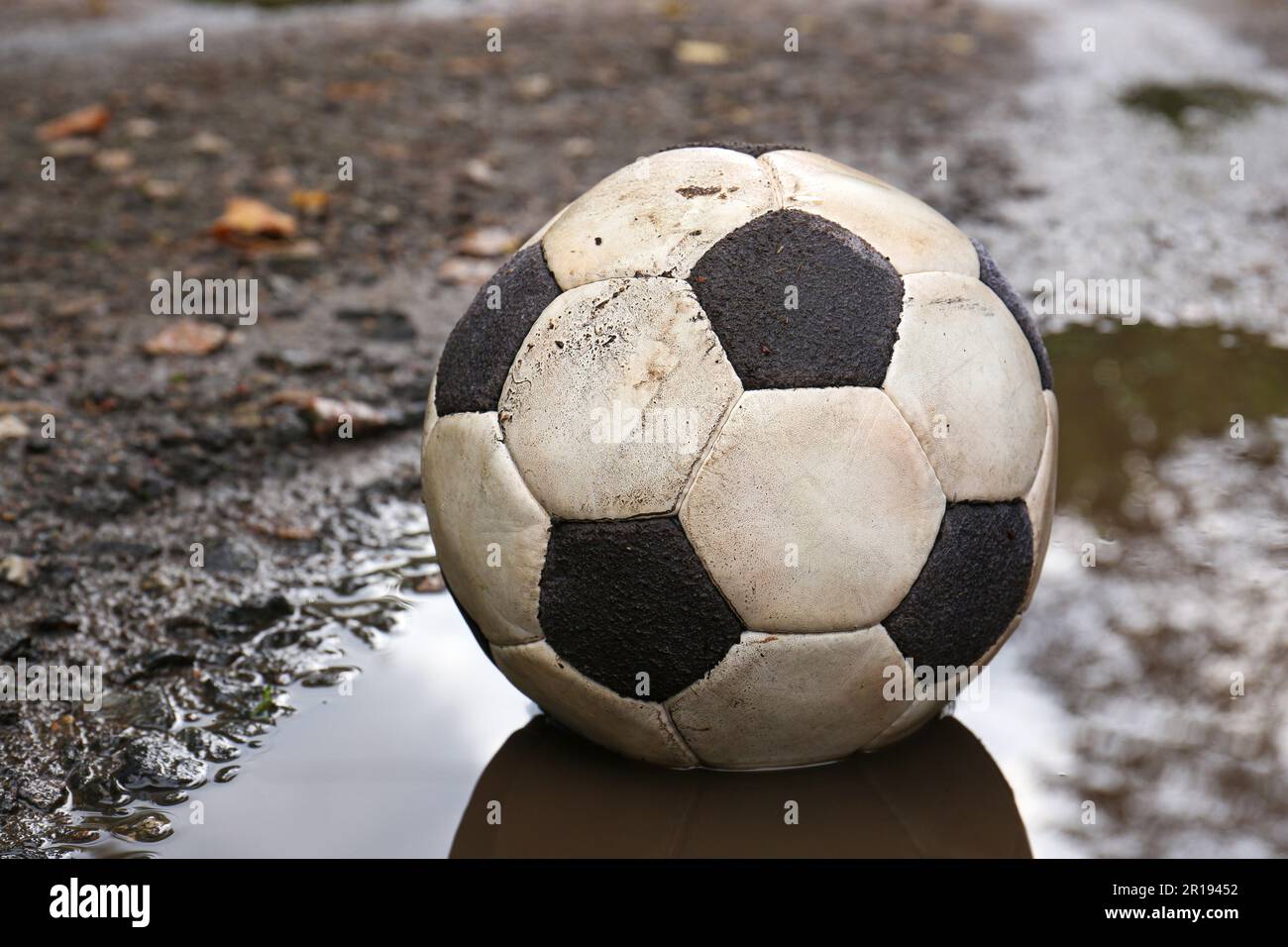 Dirty soccer ball in muddy puddle, closeup Stock Photo - Alamy