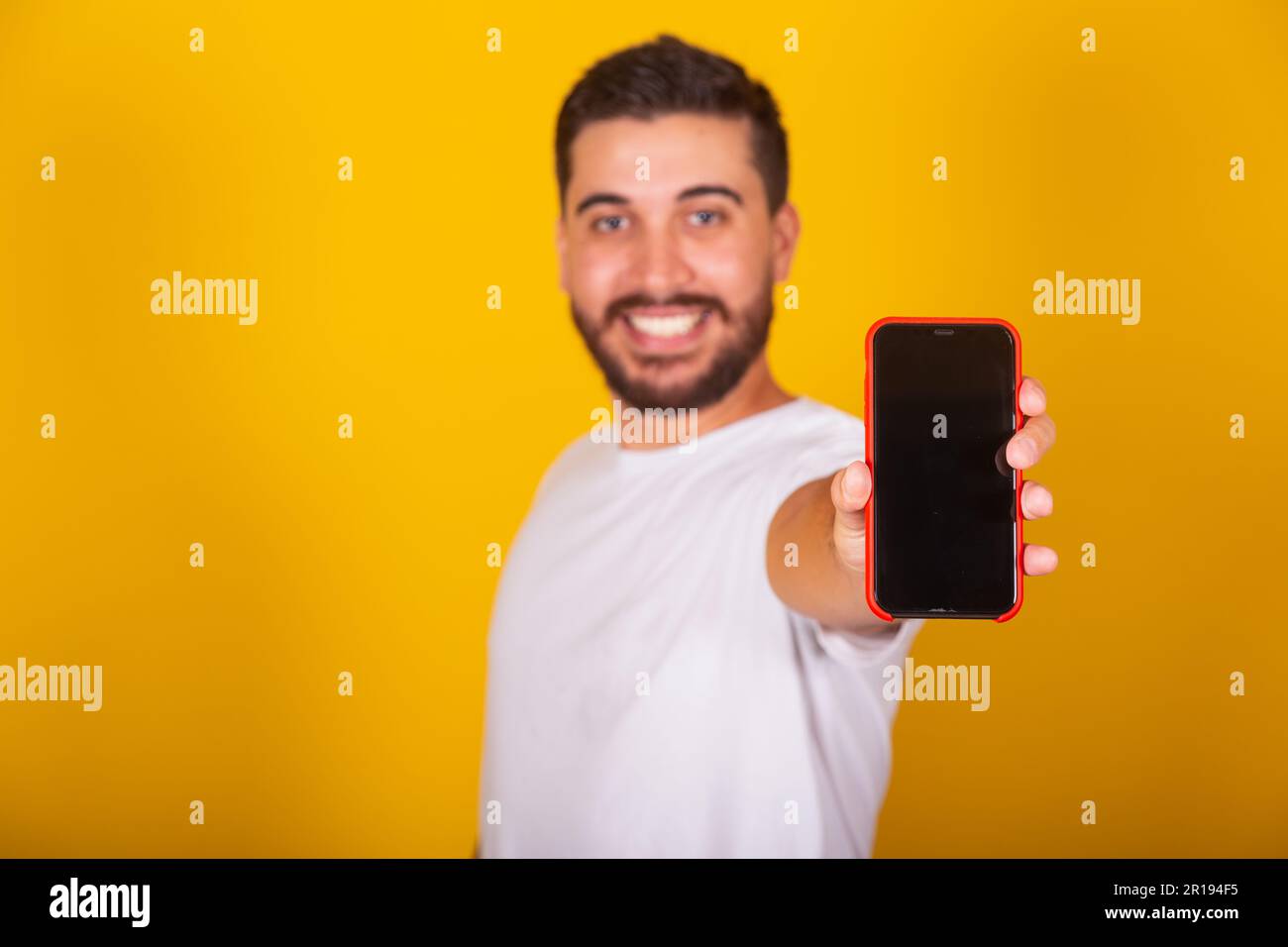 Brazilian Latin American man,Showing cellphone with outstretched hand ...