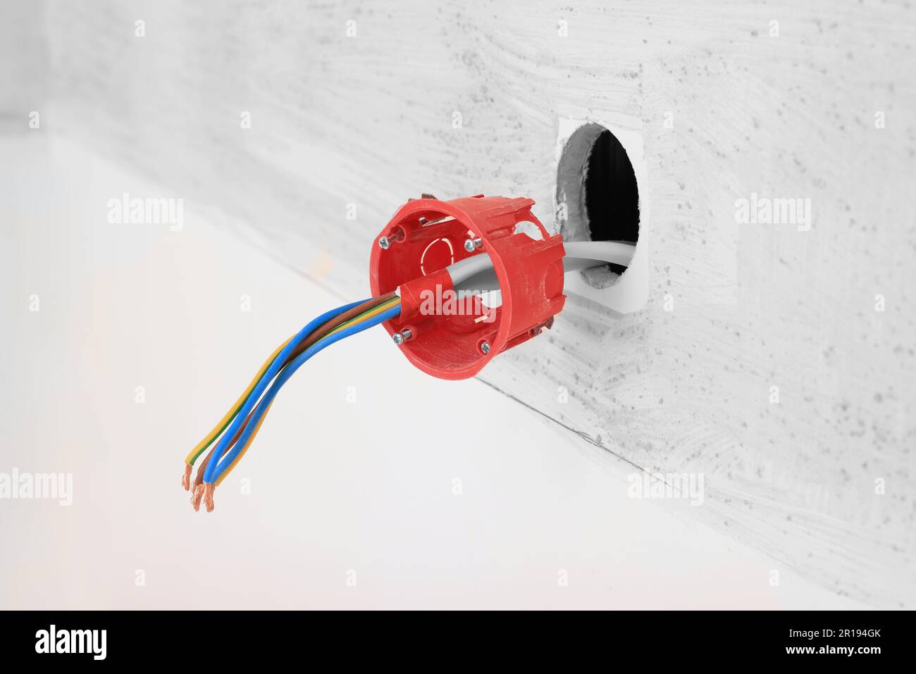 Hole for socket with wires in wall indoors, closeup. Installation of ...