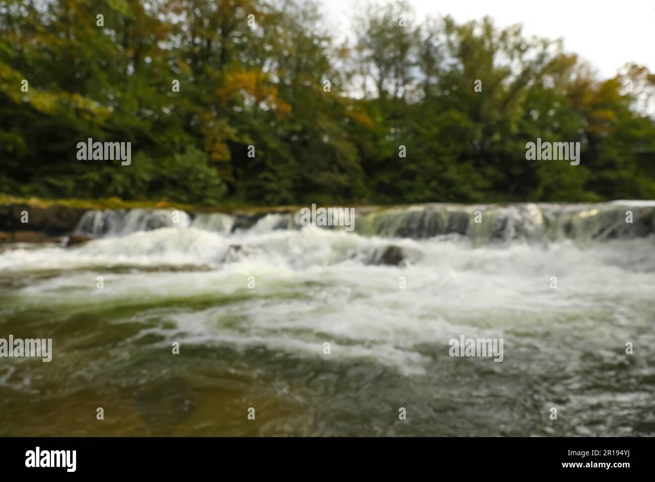 Blurred view of river with rapids near forest Stock Photo - Alamy