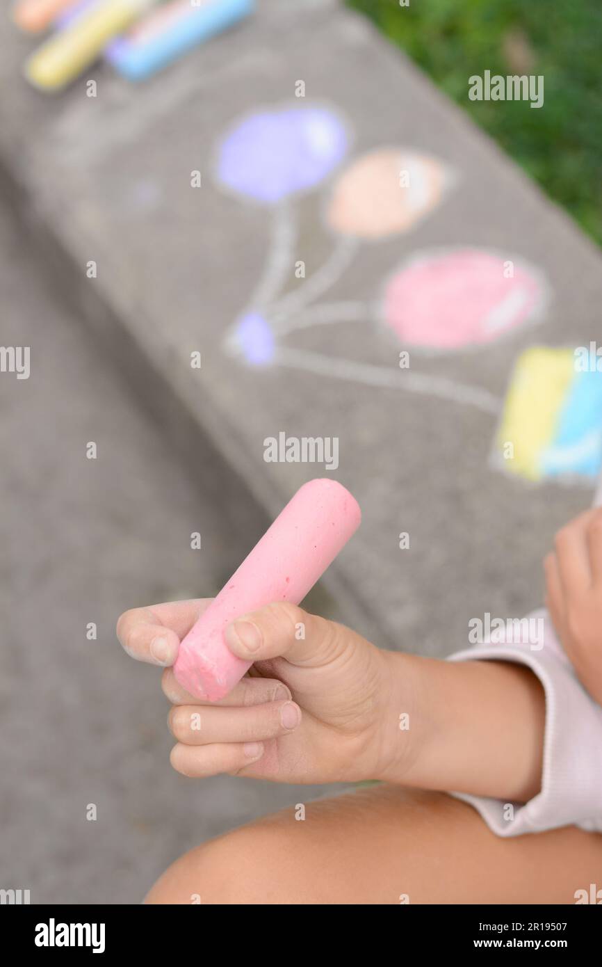 Little child chalk piece sitting on curb outdoors, closeup. Space for text Stock Photo - Alamy