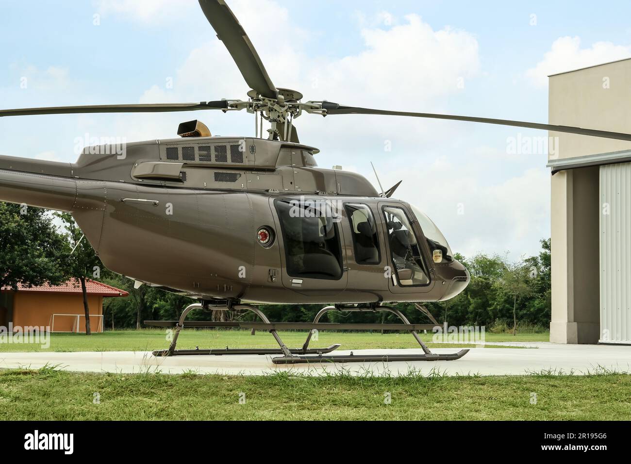 Beautiful helicopter on helipad near white hangar Stock Photo - Alamy