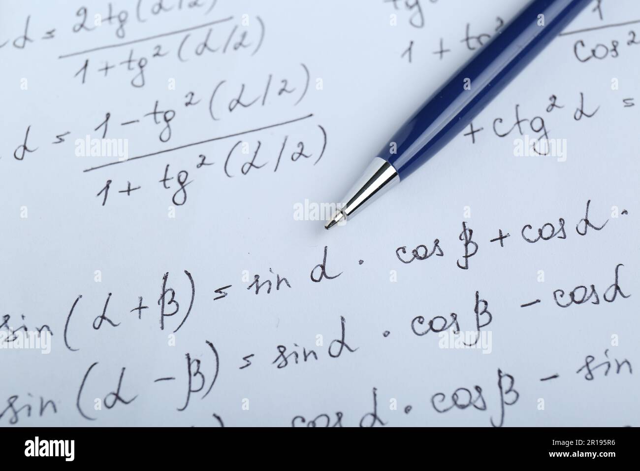 Sheet of paper with different mathematical formulas and pen, closeup ...