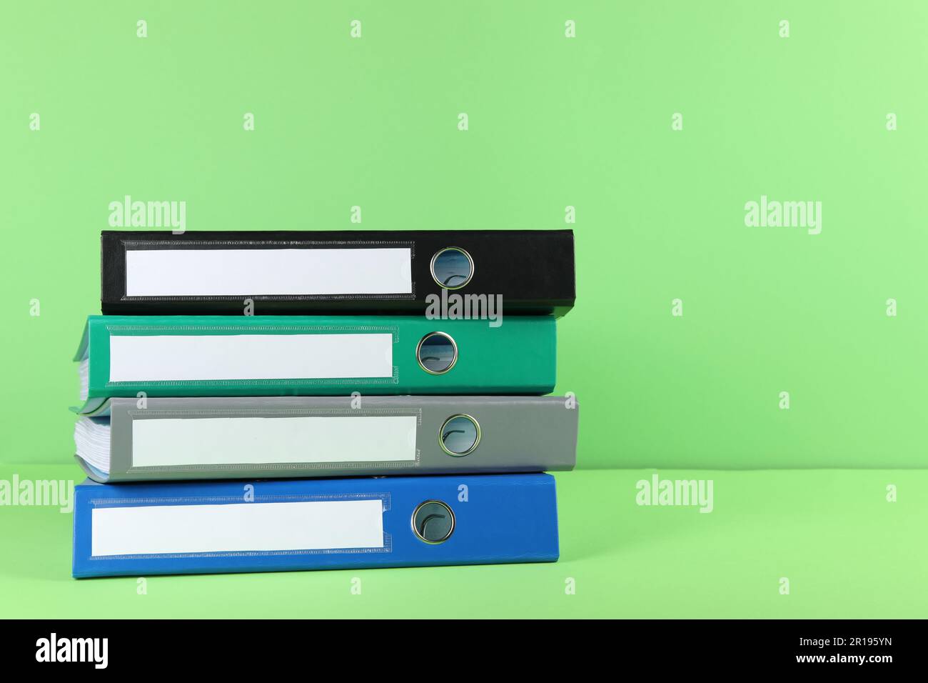 Stack of office folders on light green background, space for text Stock ...