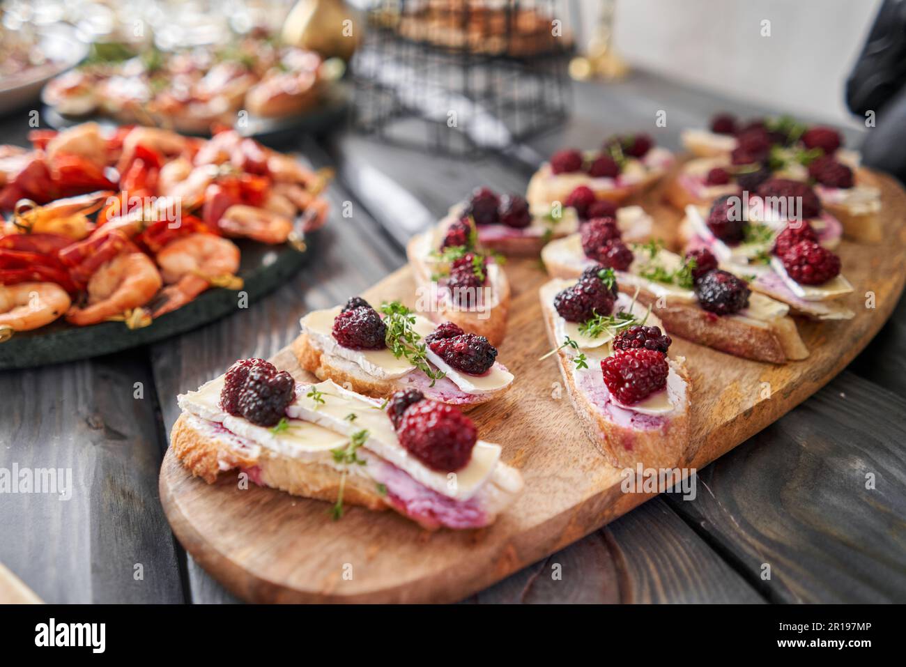 Delicious canapes with camembert and blackberries. Tasty buffet table ...