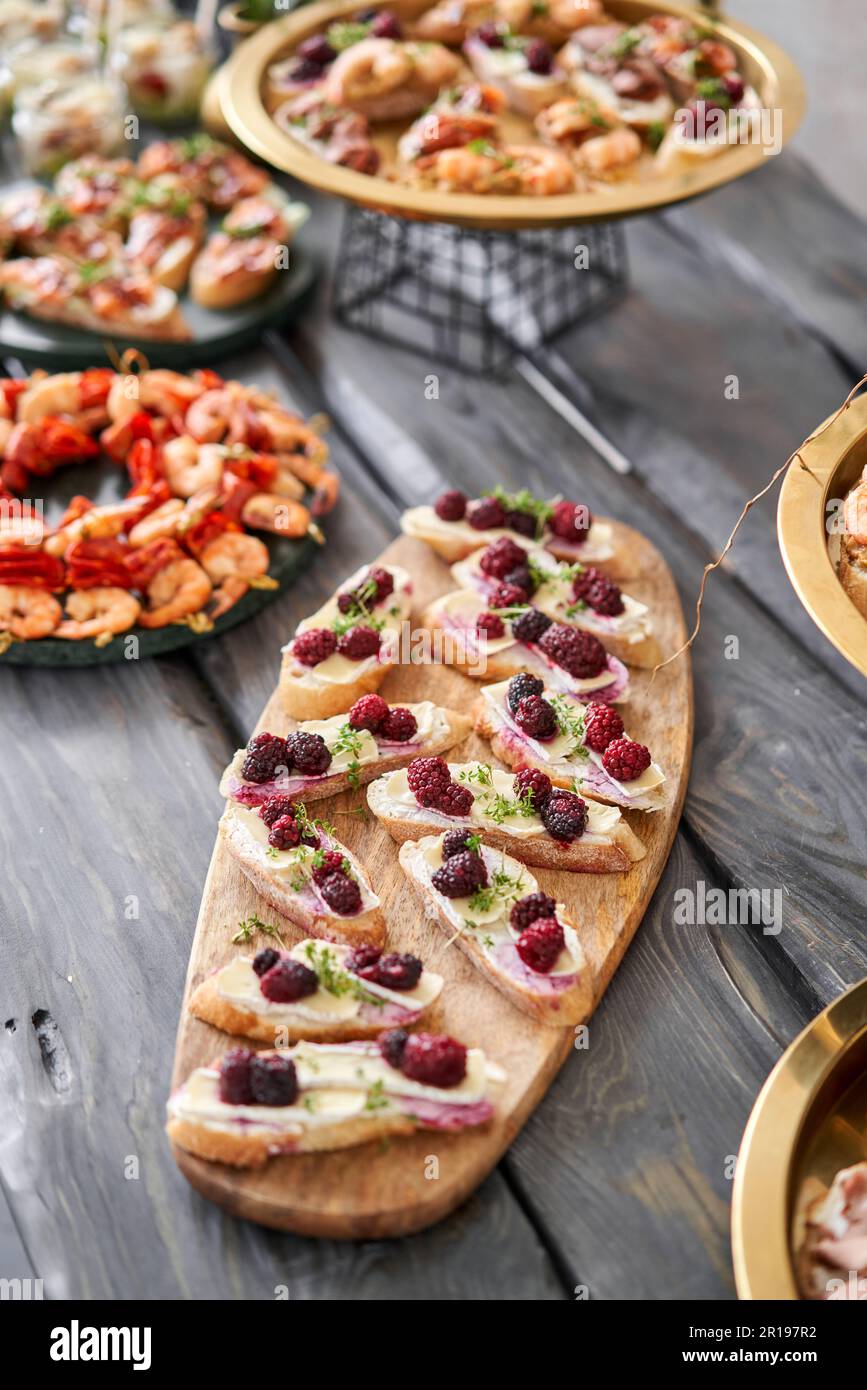 Delicious canapes with camembert and blackberries. Tasty buffet table ...