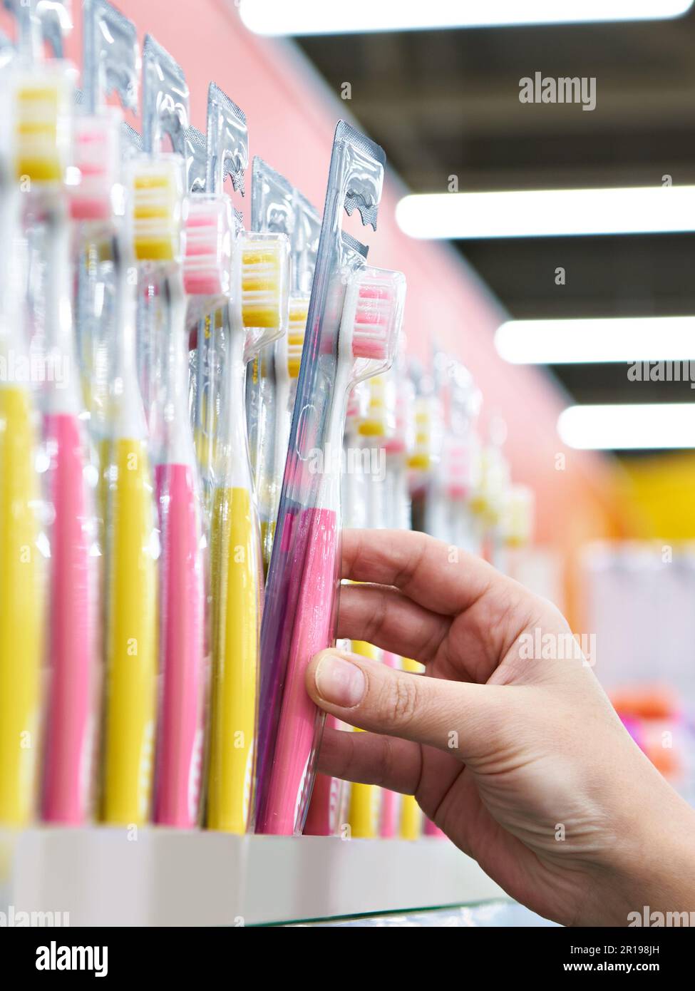 Toothbrush in a package in hand in the store Stock Photo - Alamy
