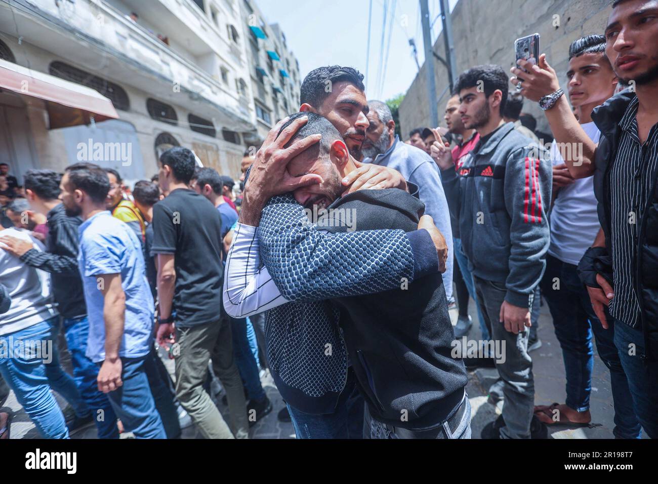 Gaza, Palestine. 12th May, 2023. A Palestinian man cries as he attends ...