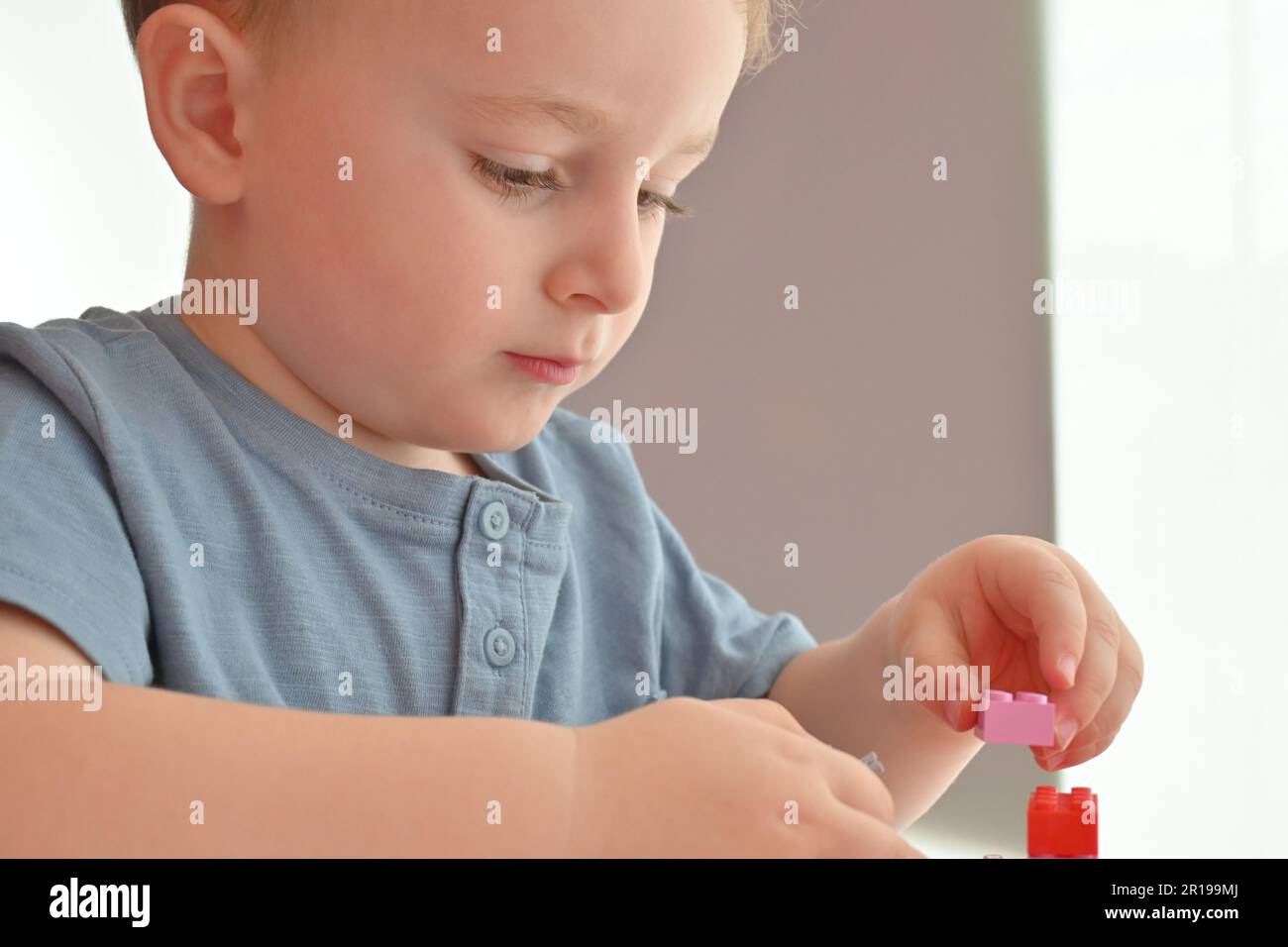 Little child playing with lots of colorful plastic toys indoor ...
