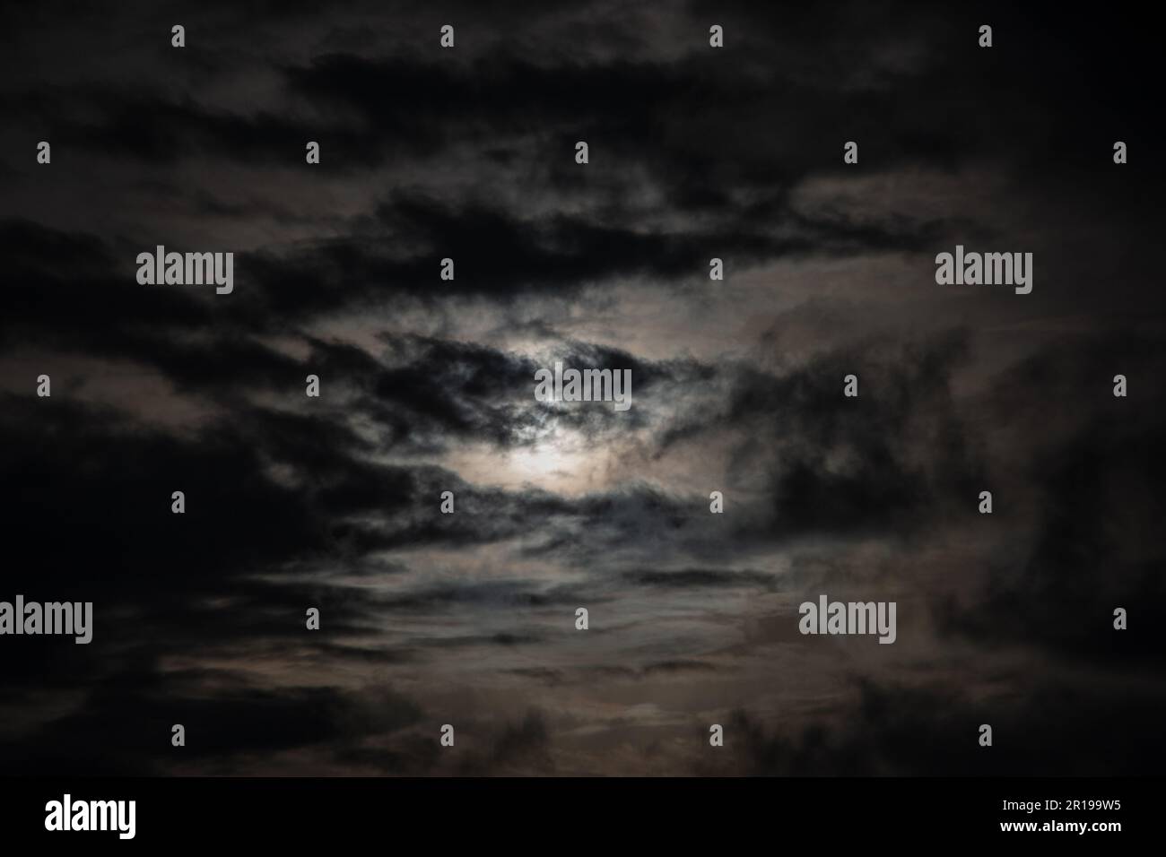 A narrow semicircle of the moon in cloudy cloudy weather. Sickle ...
