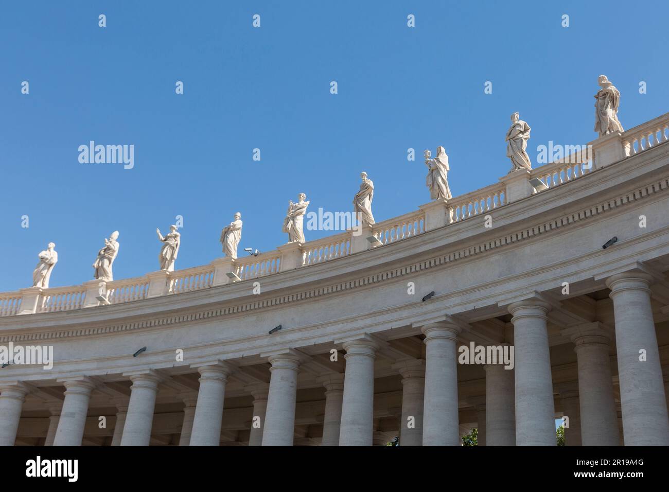 Statues of famous people above the building with columns in the Vatican ...