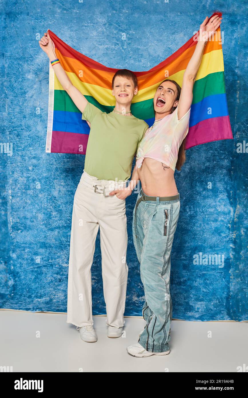 Full length of excited homosexual community in casual clothes holding ...