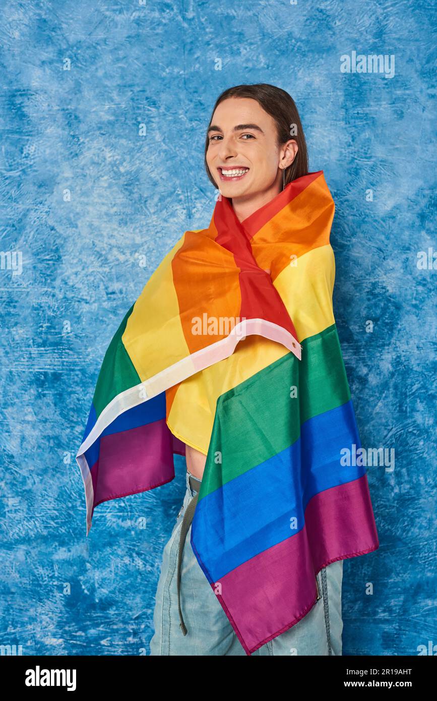 Positive long haired homosexual man looking and camera and wrapping in ...