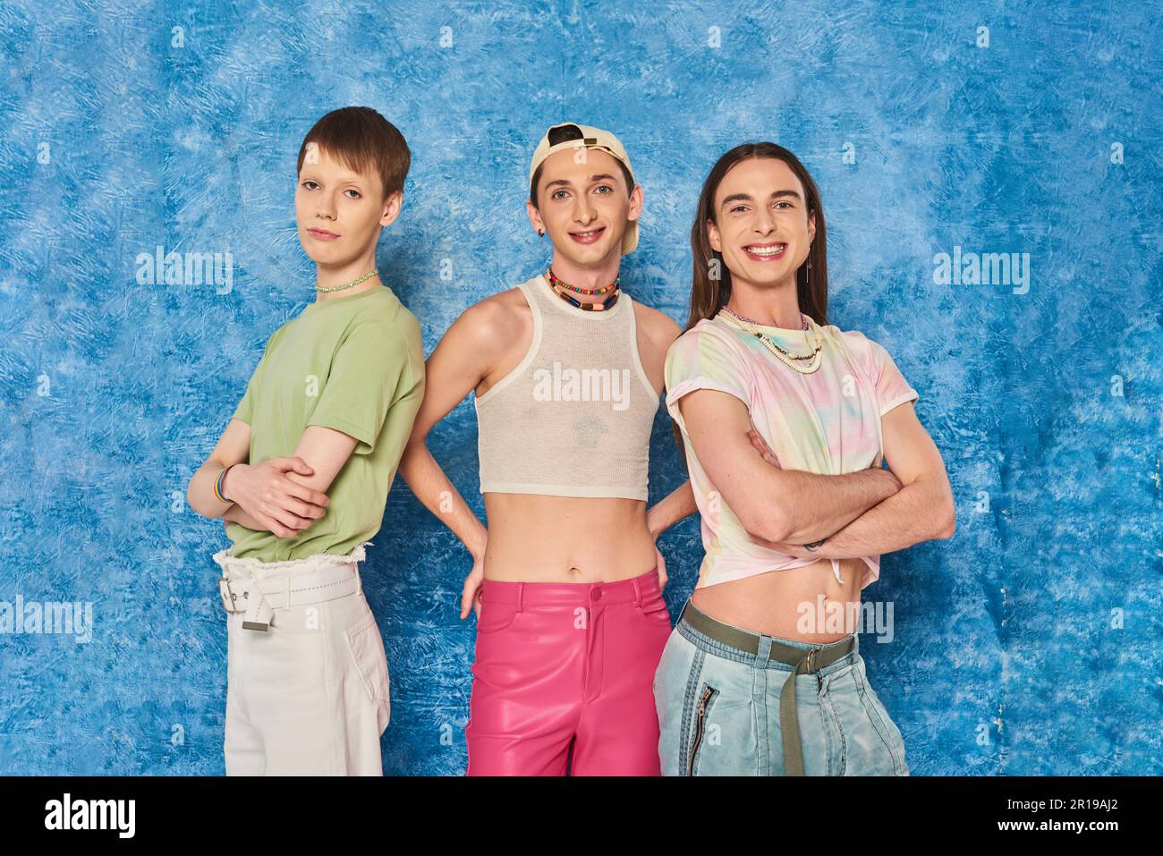 Cheerful and stylish homosexual friends looking at camera together and ...