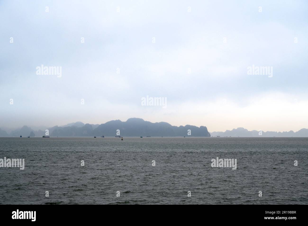 Boats dotted around at sea with a backdrop of limestone islands and ...