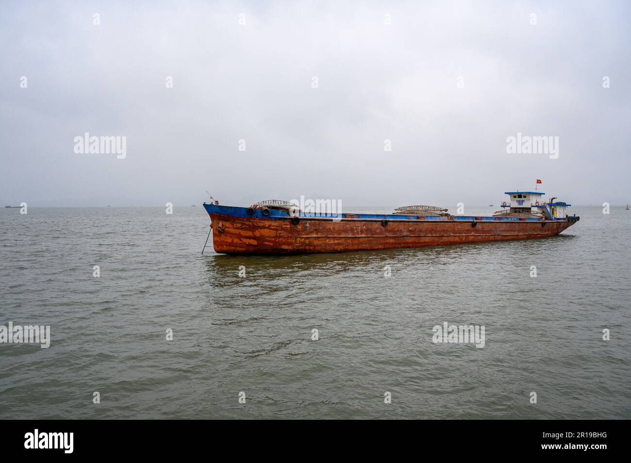 A rusty old freight ship anchored at sea in Bai Tu Long Bay, Halong Bay ...