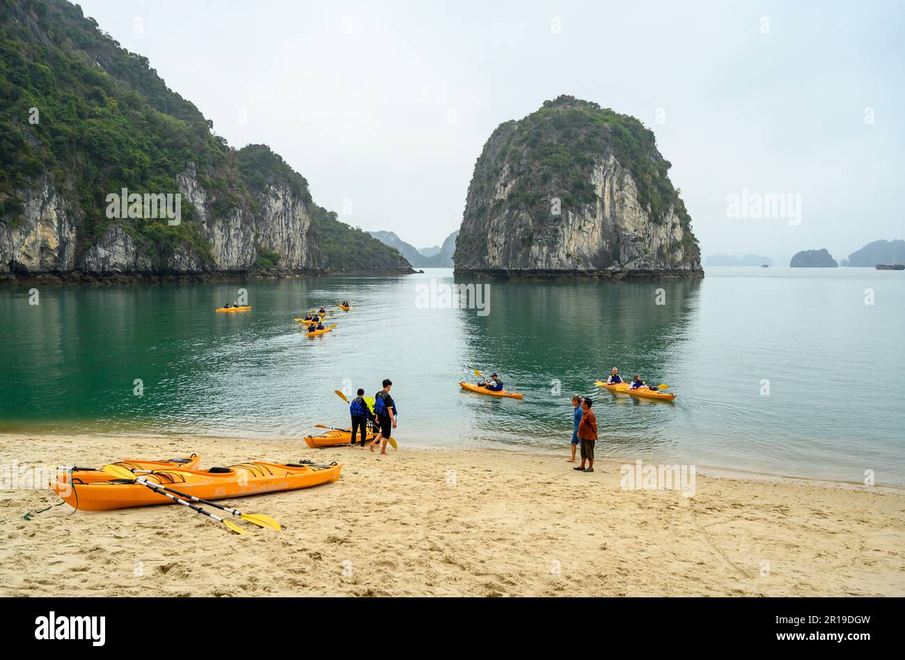 Tourists doing kayaking from a beach in Bai Tu Long Bay, Halong Bay ...