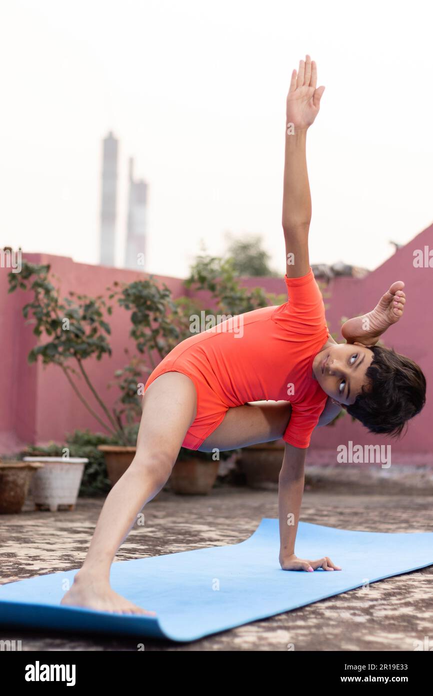 An Indian girl child practicing yoga on yoga mat outdoors Stock Photo ...